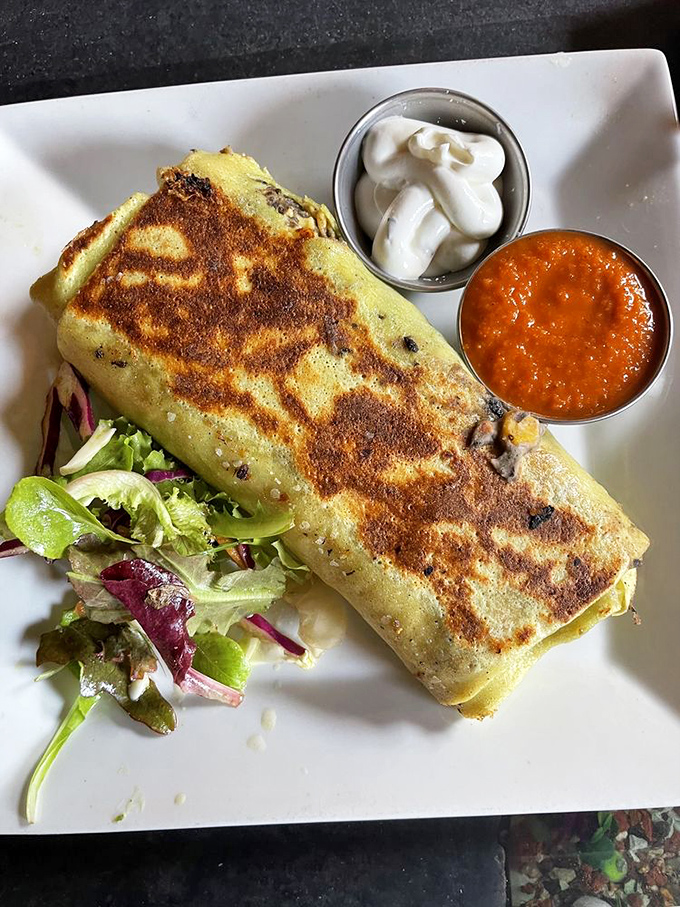 The breakfast burrito arrives like a savory sleeping bag stuffed with morning comfort and wrapped in golden perfection.