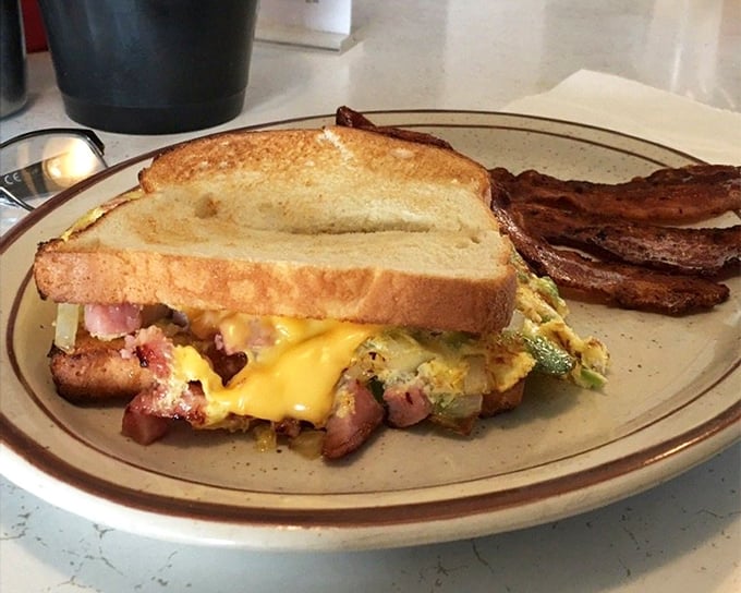 Breakfast sandwich engineering at its finest. The structural integrity of that egg-cheese-ham masterpiece deserves an architectural award. The bacon stands guard, ensuring no bite escapes.