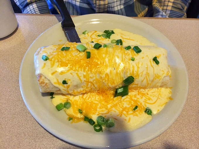 This breakfast burrito wears a golden cheese blanket and green onion confetti. It's not just filled—it's fulfilled.