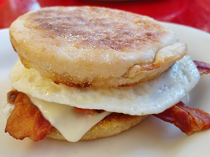 Breakfast sandwich architecture at its finest&mdash;melty cheese cascading over perfectly cooked egg and bacon on a toasted English muffin.