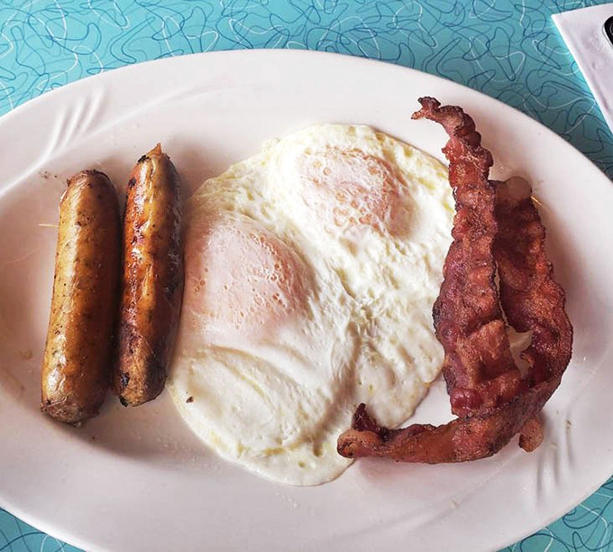 Two eggs, crispy bacon, and sausage links – the holy trinity of breakfast that works miracles at any hour.