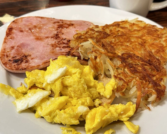 Scrambled eggs that look like clouds, ham with a perfect sear, and hash browns crispy enough to make a potato proud—breakfast doesn't get more satisfying than this.