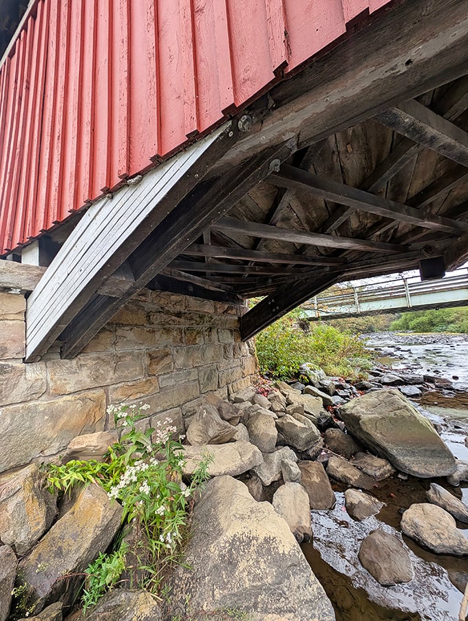 Beneath its vibrant exterior, the bridge reveals its true strength&mdash;stone foundations and wooden underpinnings that have withstood decades of rushing waters.