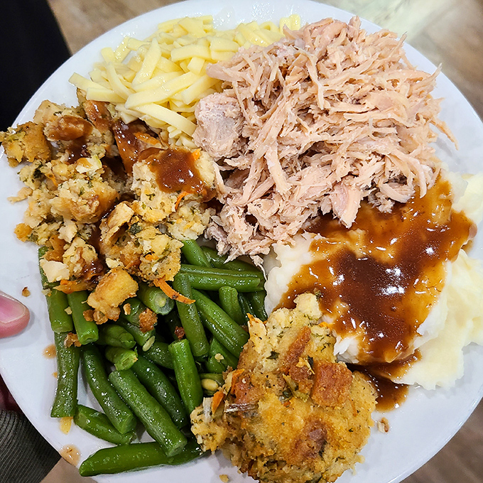 A buffet plate loaded with broasted chicken, mashed potatoes, and stuffing proves that restraint is overrated when visiting Amish Country.