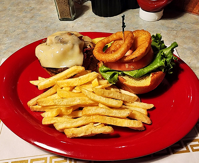 A burger that demands to be photographed before eaten, with those crispy onion rings standing guard like delicious sentinels.