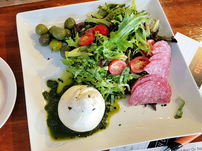 Fresh burrata, pesto, and a garden of greens create an appetizer that's practically a work of art. The kind of dish that makes you pause before diving in&mdash;but only briefly.