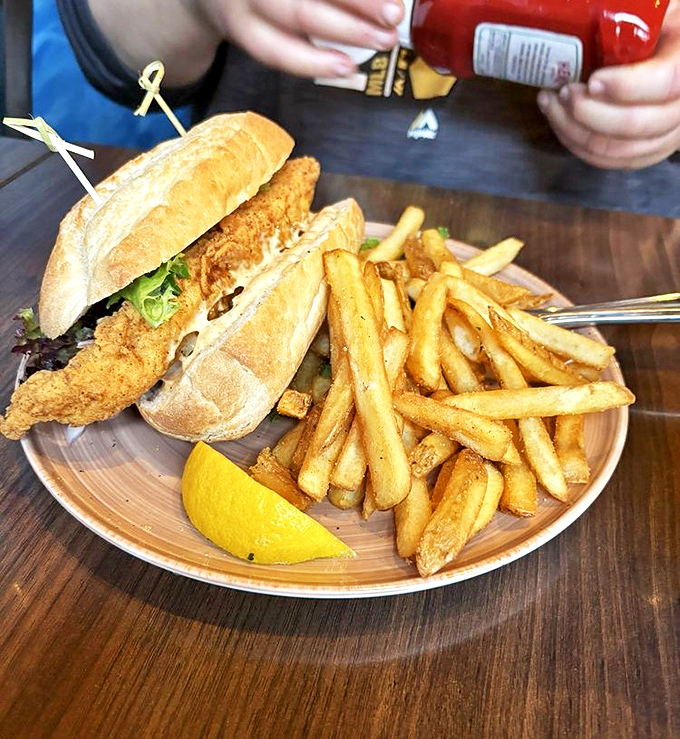 The catfish sandwich: proof that sometimes the best things in life come between two pieces of bread. Those fries deserve their own fan club.