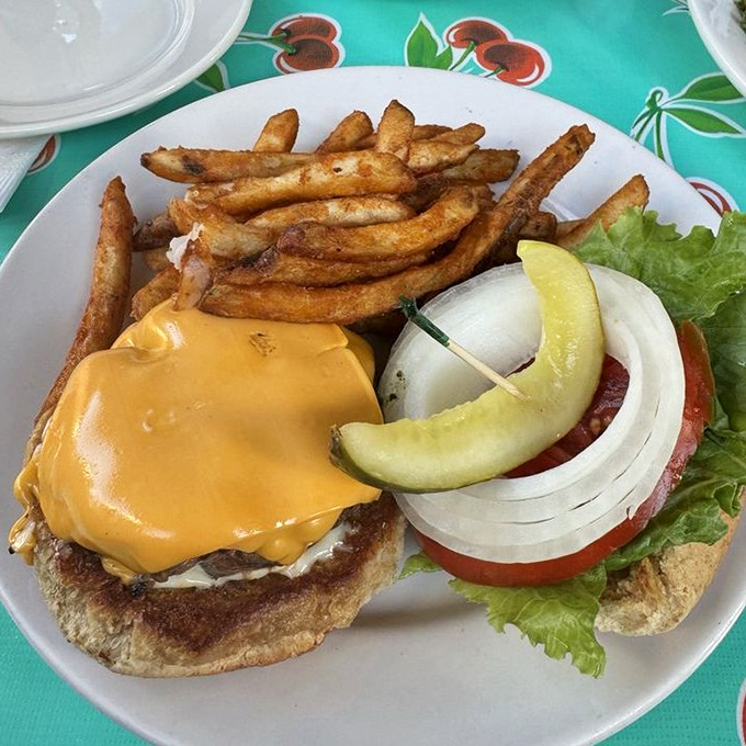 This isn't just a cheeseburger—it's a masterclass in American comfort food, complete with golden fries that crackle with each bite.