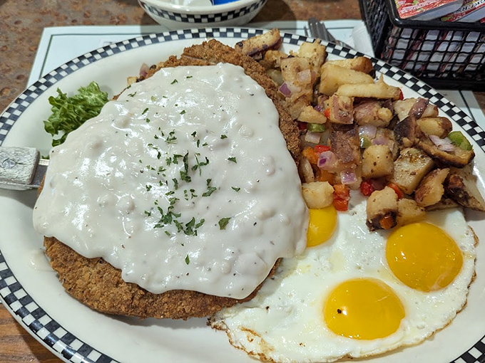 Country fried steak swimming in gravy that could make cardboard taste good, with eggs sunny-side up for moral support.
