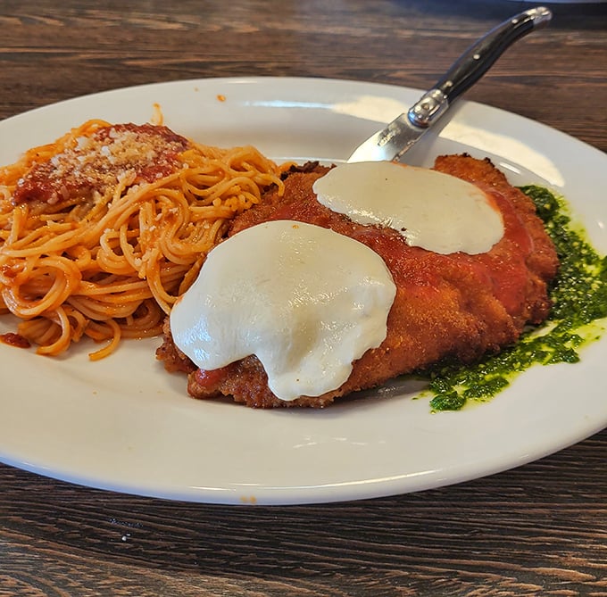 Chicken Parm done right: crispy exterior, juicy interior, melty cheese, and that side of pasta? Not an afterthought, but a co-star worthy of equal billing.