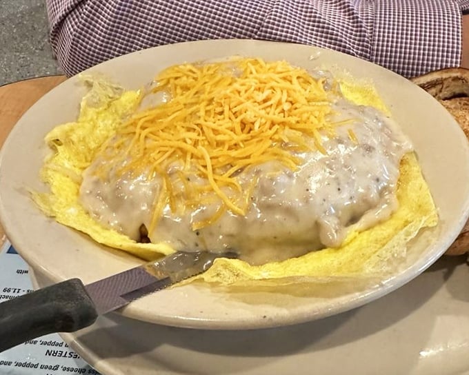 Behold the breakfast that launched a thousand naps. Creamy gravy cascading over a golden omelet with cheese standing by like a faithful companion.