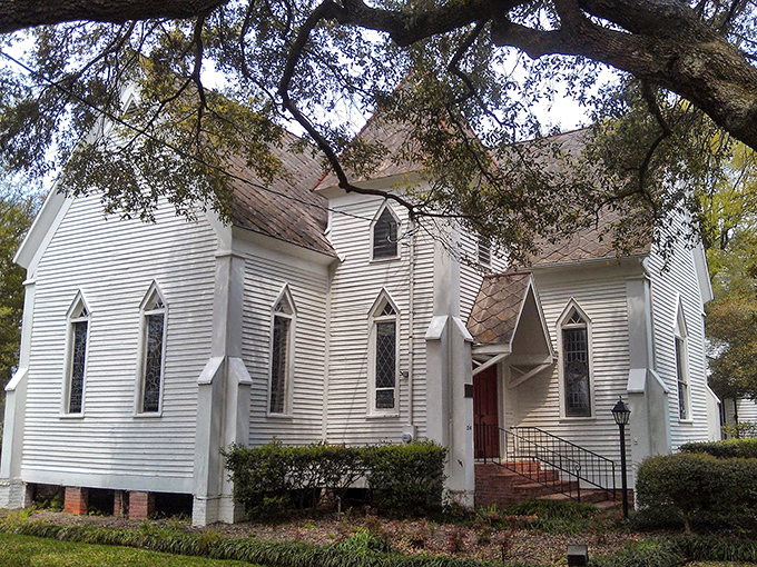 Christ Episcopal Church gleams white against the Louisiana greenery, its Gothic windows like portals to a more contemplative time.
