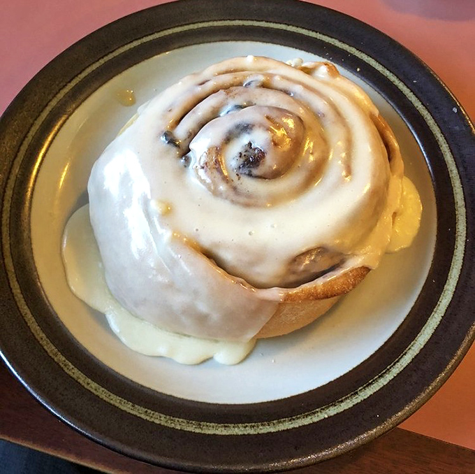 This cinnamon roll isn't just breakfast; it's an event. The icing melts into warm dough creating rivers of sweetness that make Monday mornings bearable again.