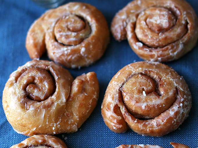 Cinnamon rolls that spiral into perfection, glistening with glaze that catches the light like morning dew on spiderwebs.