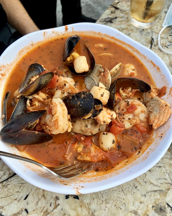 The cioppino arrives like an underwater treasure chest &ndash; mussels, clams, and shrimp swimming in a tomato broth sea.