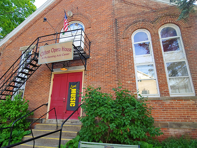 The Clifton Opera House stands proud with its brick facade and crimson door, proving small towns can deliver big culture.