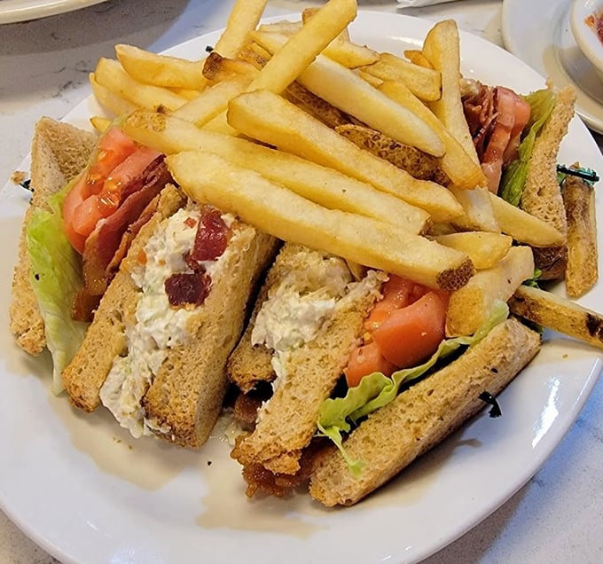 The club sandwich: architectural marvel meets flavor explosion. Three stories of deliciousness that makes skyscrapers jealous of its perfect construction.