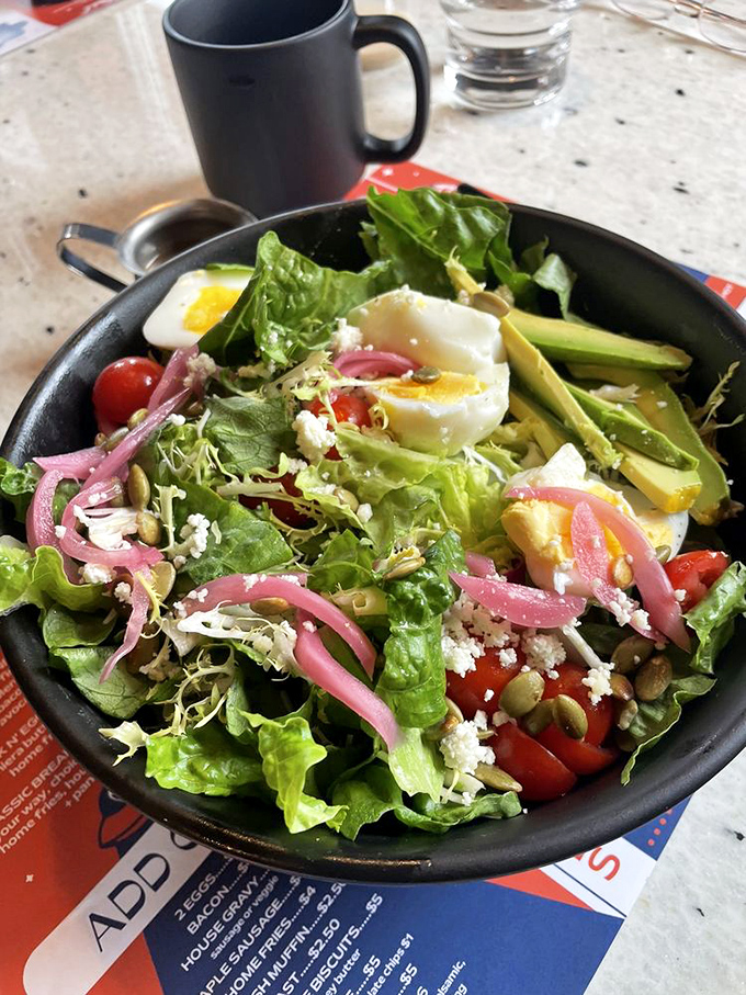 Fresh greens playing host to a party of pickled onions, hard-boiled eggs, and colorful vegetables—proof that salads don't have to be punishment.