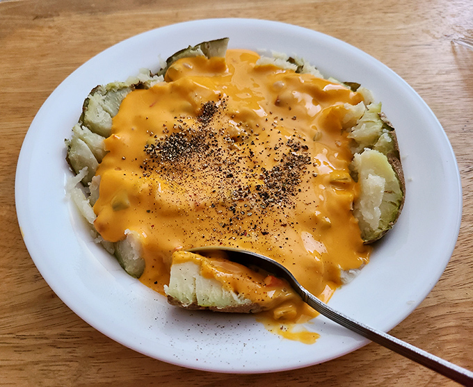 A loaded baked potato smothered in cheese sauce that asks the important question: "Why settle for a side dish when you could have a masterpiece?"