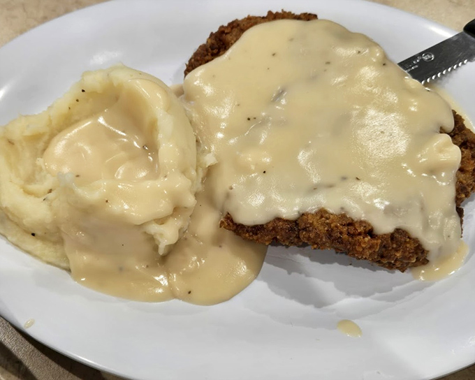 Country fried steak smothered in creamy gravy that cascades over the crispy coating like a delicious waterfall. This is what comfort food dreams are made of.