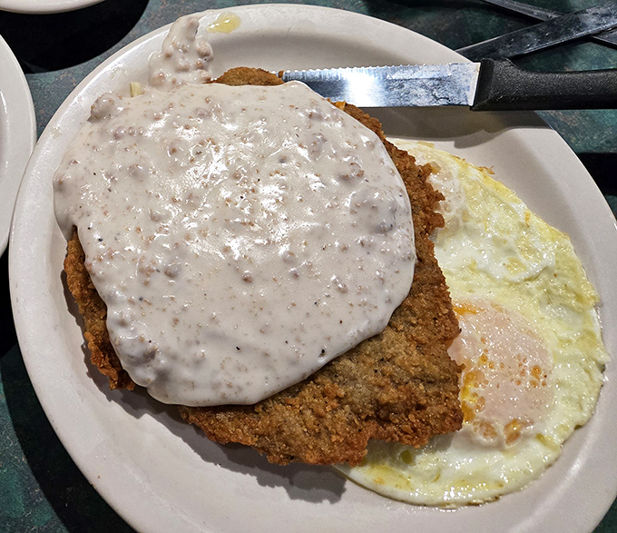 Country fried steak smothered in peppery gravy alongside sunny-side-up eggs&mdash;breakfast of champions or dinner of dreams? Why choose?