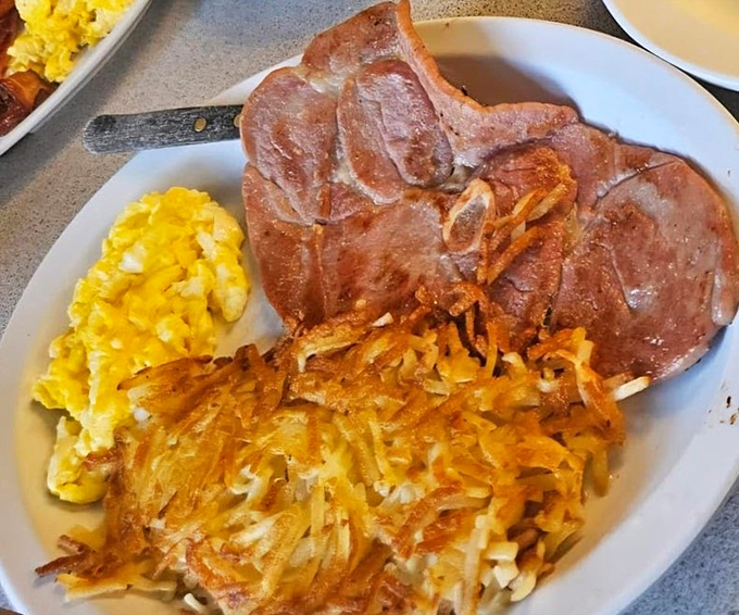 Ham that's been smoked longer than some marriages last, paired with eggs and hash browns that'll make you forget your name.