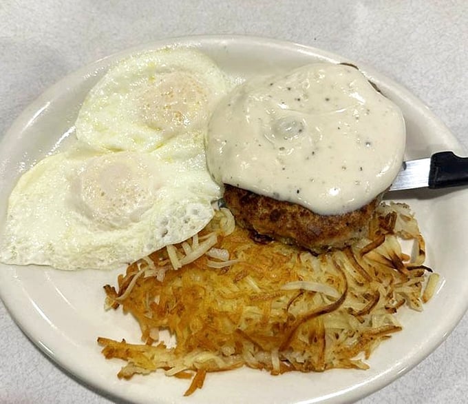 Country fried steak with gravy alongside sunny-side-up eggs&mdash;proof that breakfast can be both a hug and a handshake to start your day.