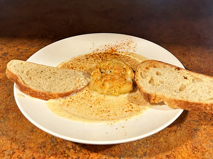 This crab bisque isn't just soup; it's a warm hug in a bowl with two slices of bread standing by for dipping duty.