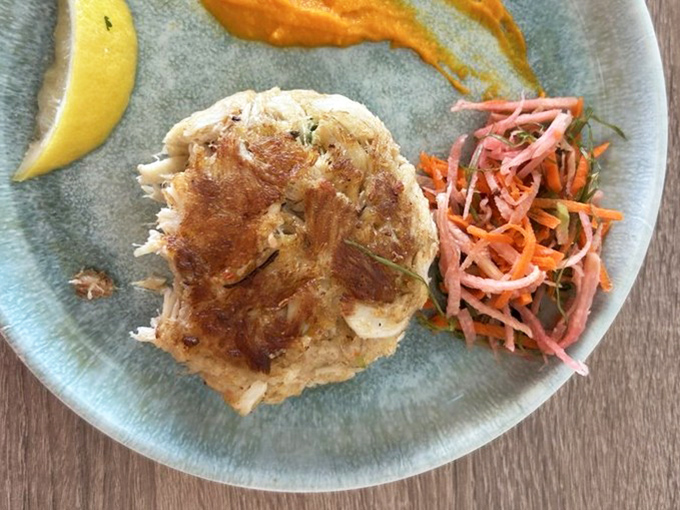 The humble crab cake, elevated to art form&mdash;golden-crisp exterior giving way to sweet, delicate meat that tastes like the ocean just moments ago.