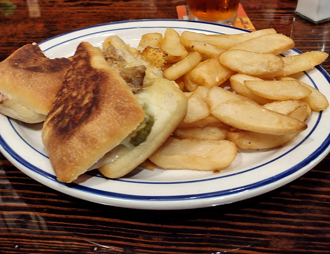 A sandwich that bridges the gap between lunch and dinner, nestled alongside fries that could make a Frenchman weep with joy.