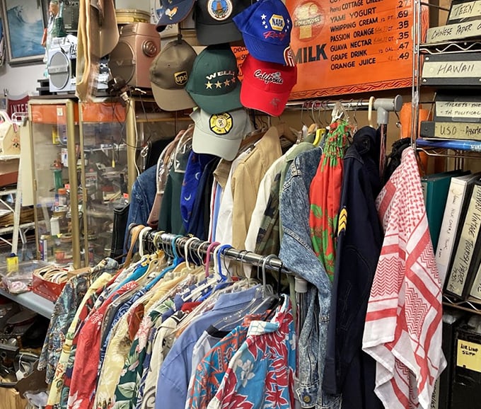 Vintage aloha shirts and baseball caps hang like colorful flags of nostalgia, each pattern a postcard from fashion's past.