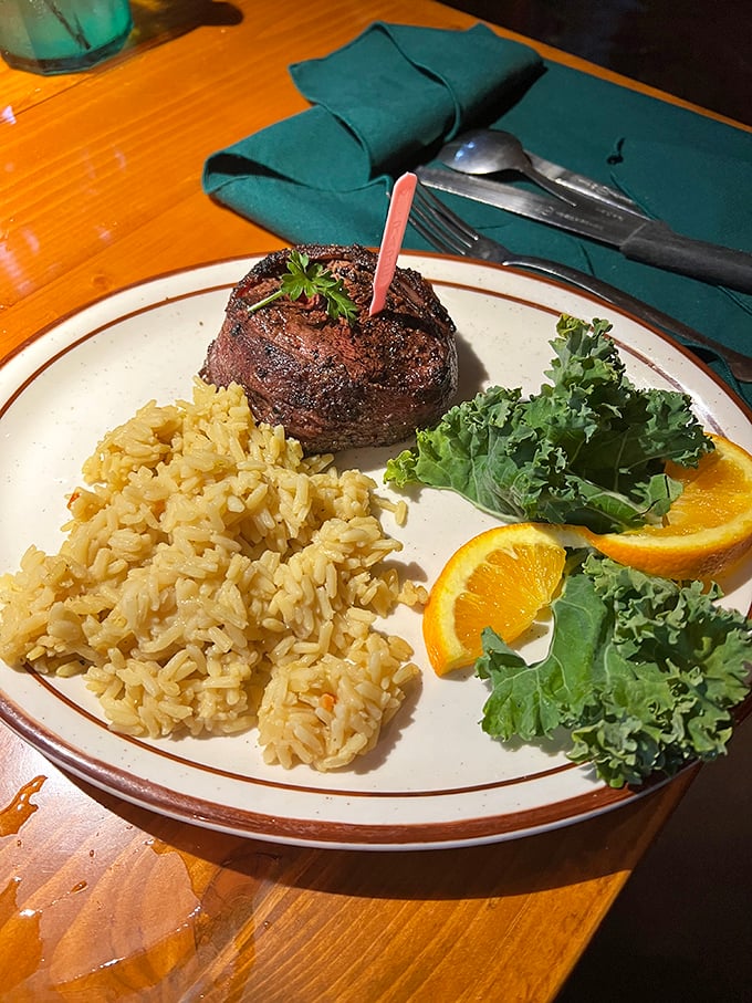 The filet mignon stands tall like a meaty monument to perfection, flanked by rice that knows its supporting role.