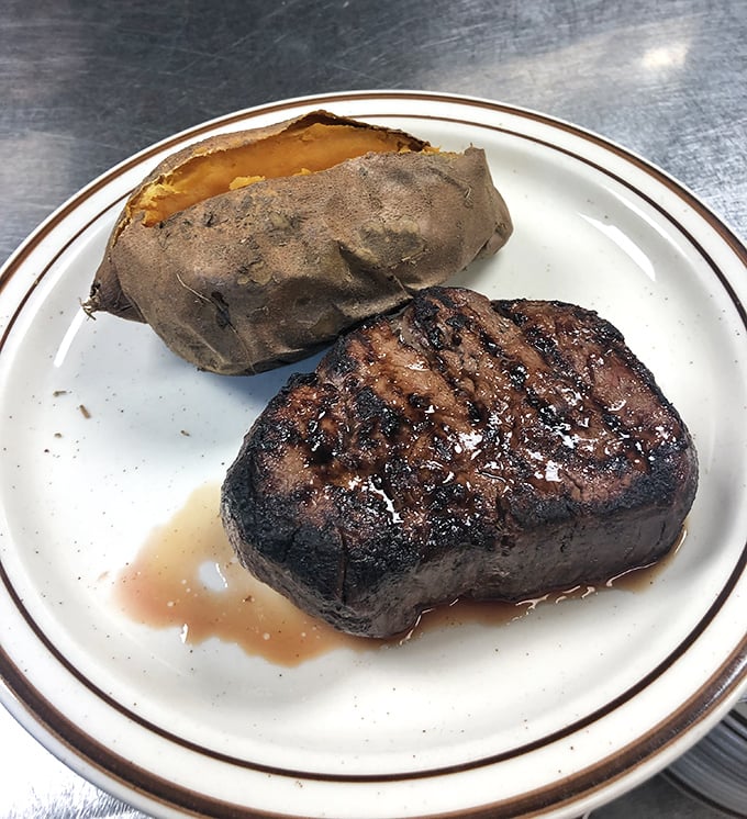 A perfectly cooked filet mignon alongside a baked potato&mdash;simple perfection that proves sometimes the classics need no improvement, just proper execution.