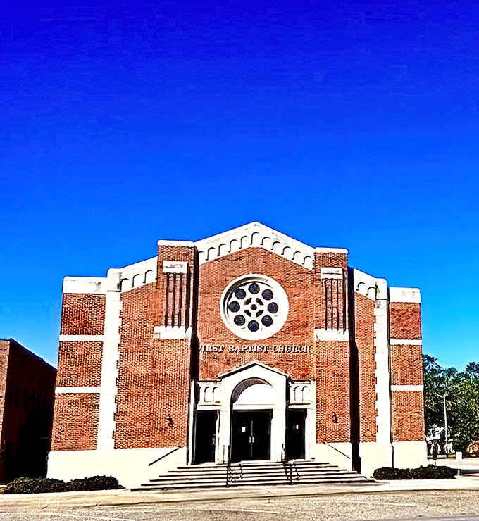 First Baptist Church of Foley stands as an architectural testament to brick craftsmanship and community faith, its rose window catching the morning light.