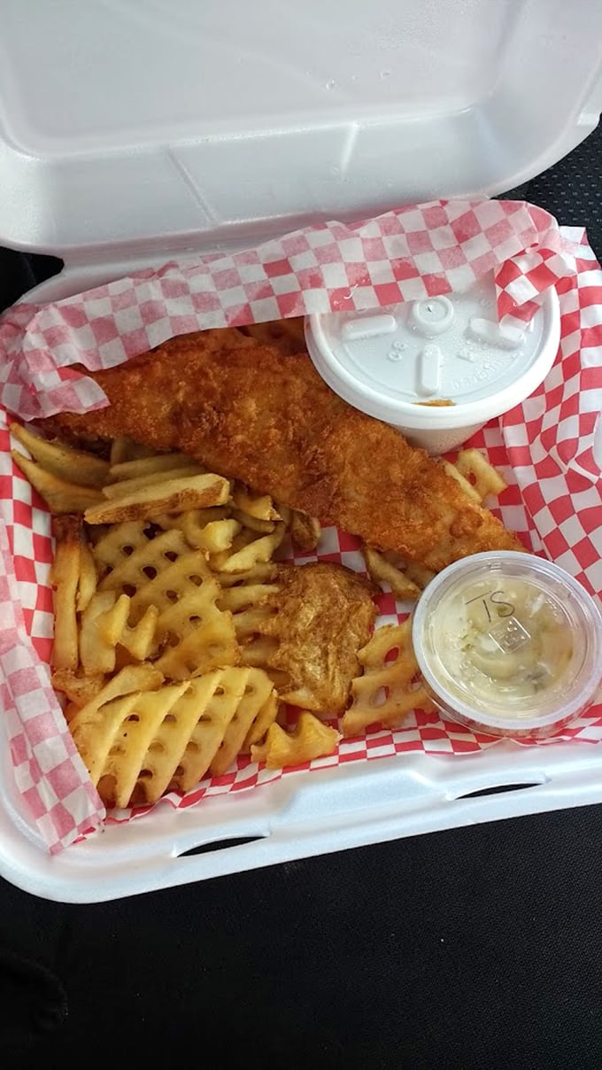 Golden-battered fish and waffle fries served in classic red baskets – seafood gets the heartland treatment.