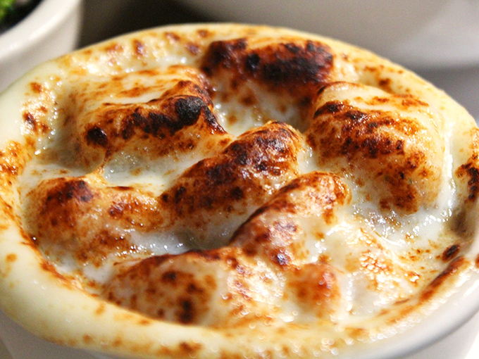 Bubbling cheese forms a golden canopy over this French onion soup &ndash; a volcanic crater of comfort that's worth every potential chin burn.