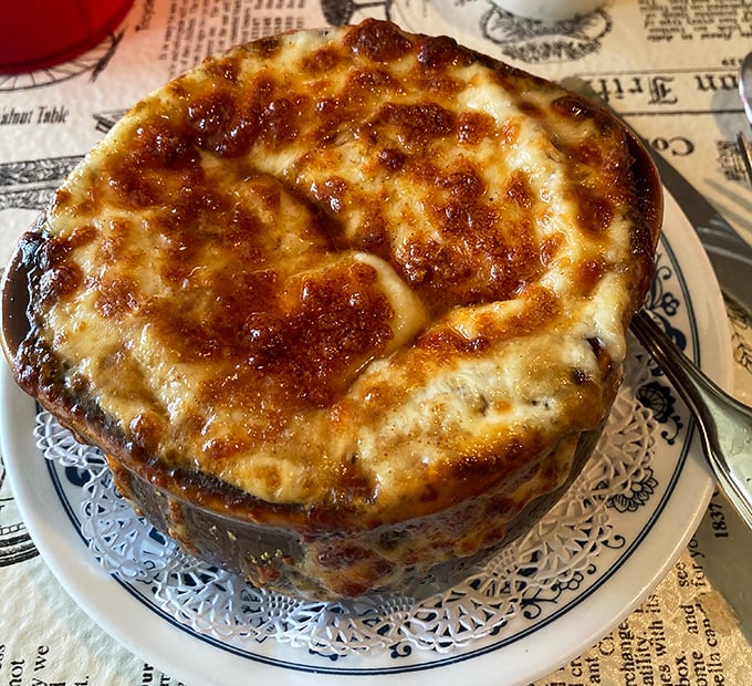 This French onion soup isn't just topped with cheese &ndash; it's wearing a magnificent crown of bubbling, bronzed goodness that demands a moment of silence.