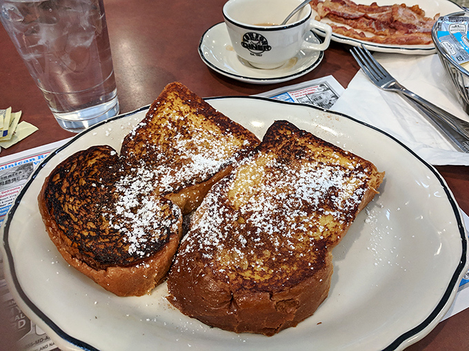French toast that's achieved celebrity status &ndash; thick-cut bread transformed into a caramelized masterpiece, dusted with powdered sugar like fresh snow on Christmas morning.