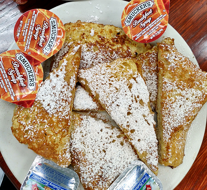 French toast thick enough to require structural engineering, golden-brown and ready to soak up all that syrup you're about to pour.