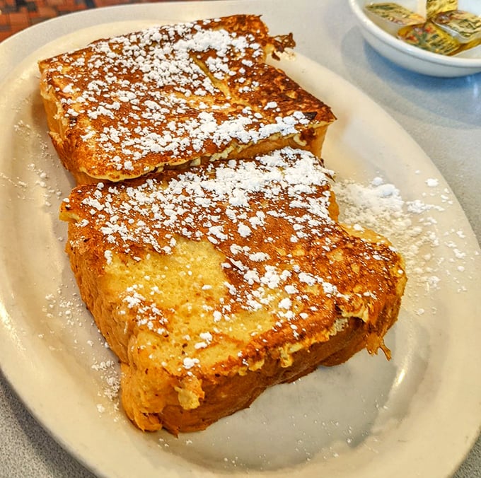 French toast so perfectly golden it belongs in Fort Knox, dusted with powdered sugar like the first perfect snowfall of winter.