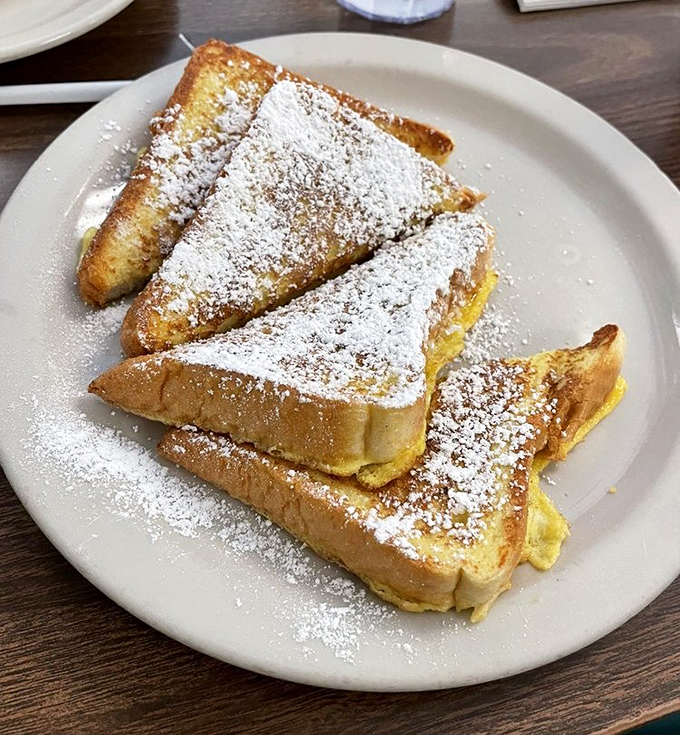 French toast dusted with powdered sugar like fresh snow on golden, custardy bread slices.