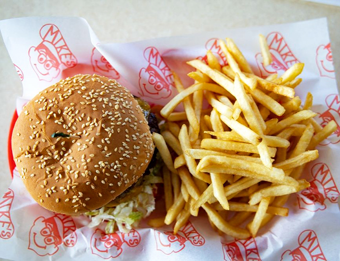 The holy trinity of American comfort food: a sesame-studded burger and golden fries on Mike's signature wrapper. Simplicity that speaks volumes.