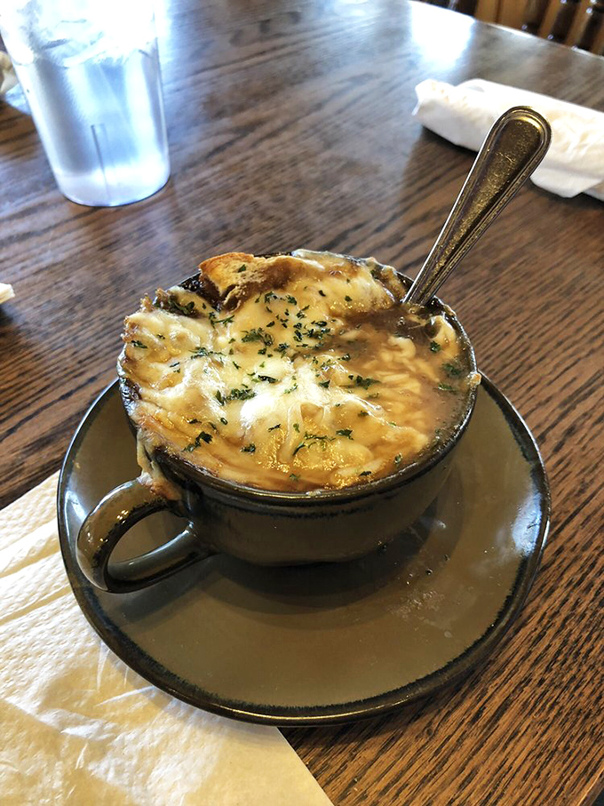 The French onion soup arrives like a bubbling cauldron of comfort, with that glorious cheese cap that stretches with each spoonful.