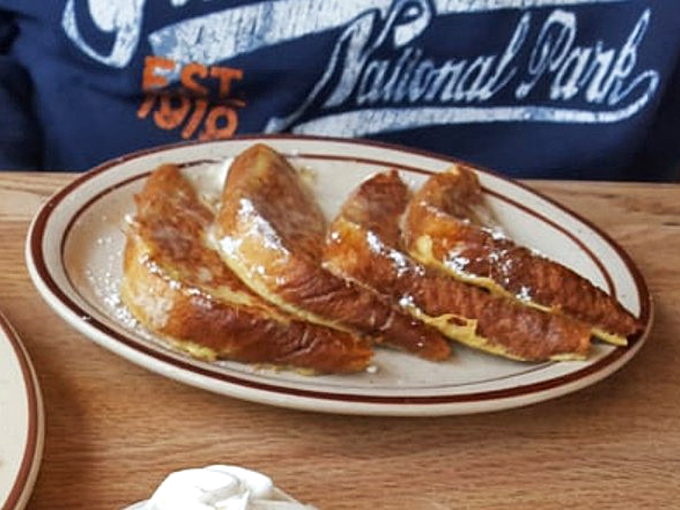 French toast that's achieved that mythical balance – crispy edges, custardy center, and enough maple syrup to make a Canadian weep with joy.