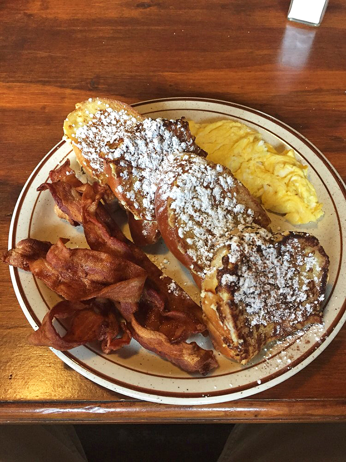French toast that would make France jealous—thick-cut challah transformed into a powdered sugar masterpiece that belongs in the breakfast hall of fame.