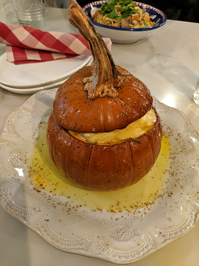 A roasted pumpkin stuffed with what appears to be cheesy goodness &ndash; autumn on a plate that screams "fall in love with me" at first sight.