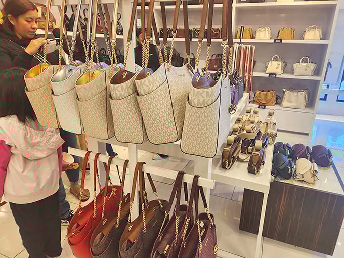 Michael Kors handbags hang like ripe fruit, ready to be plucked by savvy shoppers who know the difference between retail and outlet pricing.
