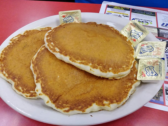 These pancakes have achieved the golden-brown perfection that home cooks spend lifetimes trying to master. Butter packets standing by.