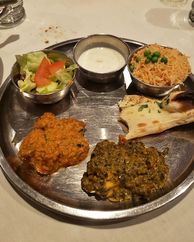 The thali experience: multiple metal bowls creating a personal flavor festival where every bite offers a different delicious conversation with your taste buds.