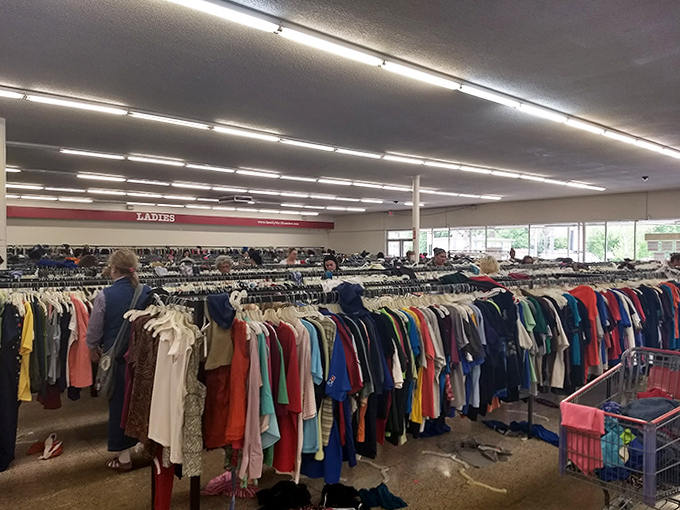 Sunlight streams through windows as shoppers embark on their quest, each colorful garment a possibility waiting to be discovered.